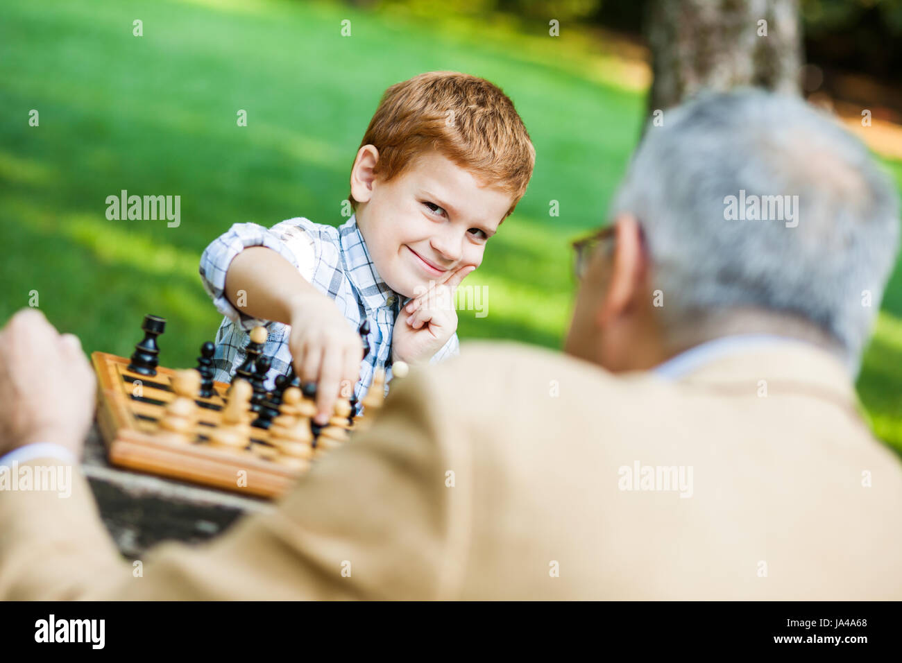 Grandfather and grandson are playing chess in park Stock Photo - Alamy