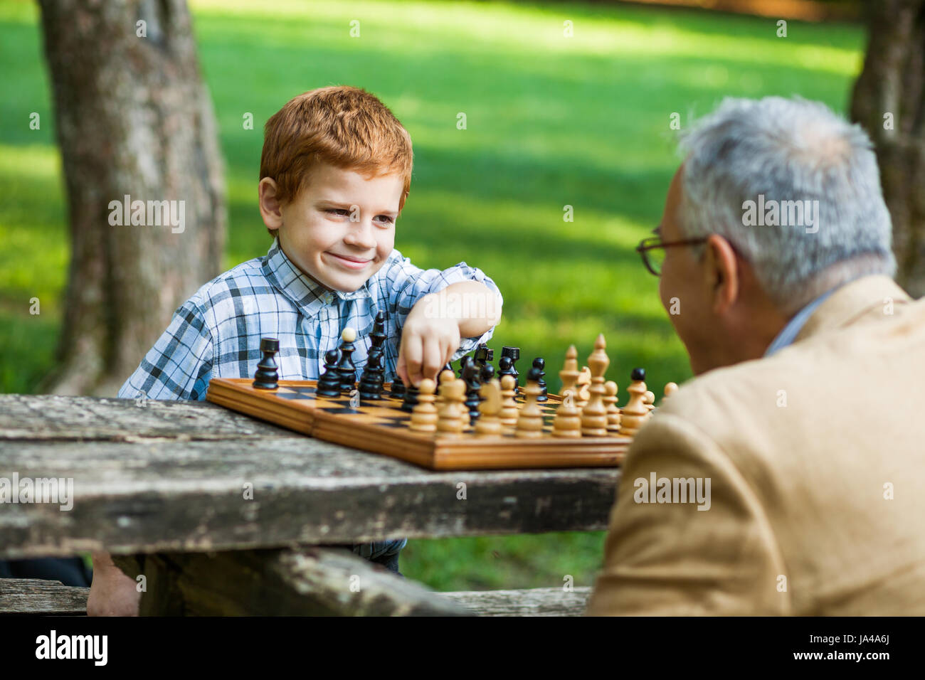 Grandfather and grandson are playing chess in park Stock Photo - Alamy