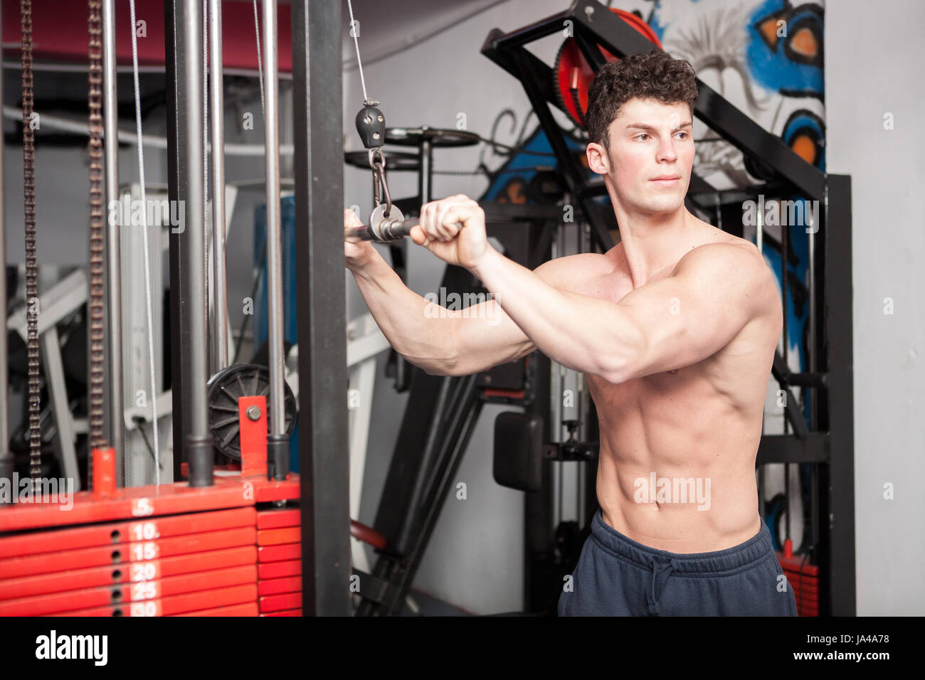 Strong man exercising in the gym. Lifting heavy weights. Bodybuilder ...