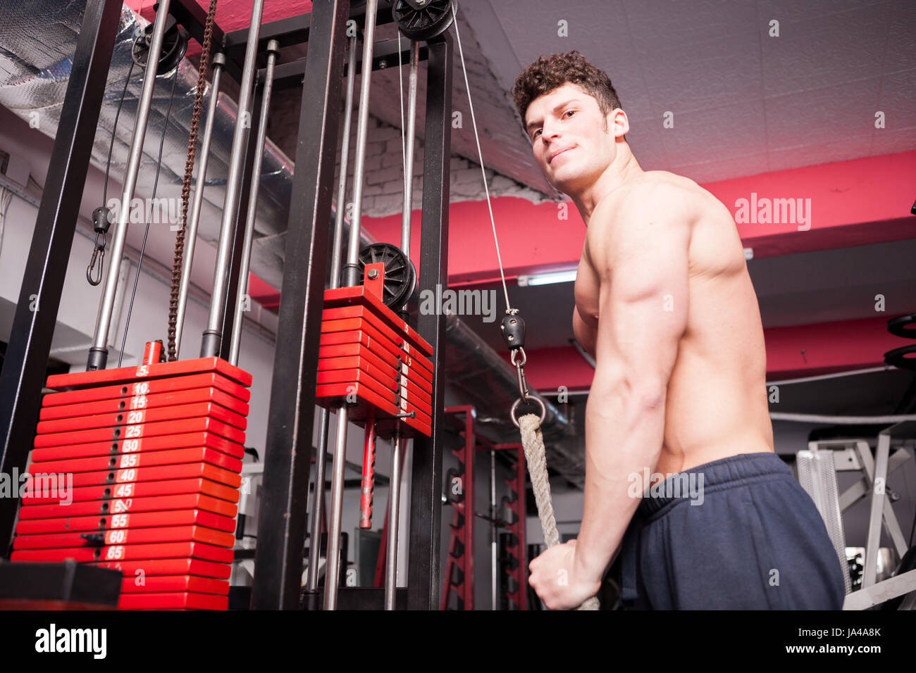 Muscular strong guy exercising in the gym. Lifting heavy weights ...