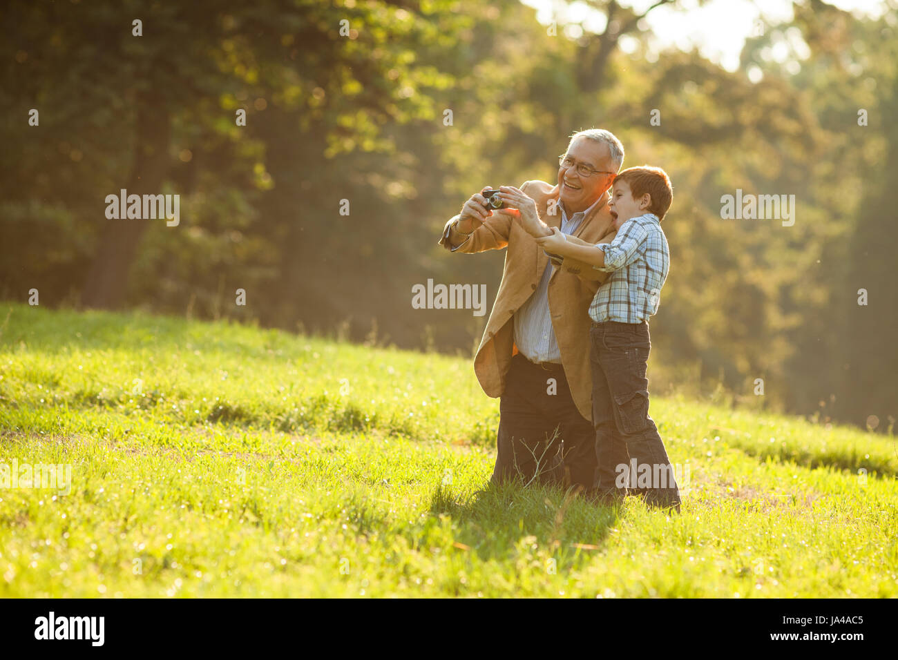 Grandfather and grandson in park Stock Photo - Alamy