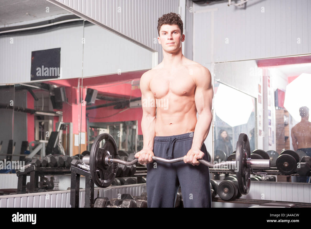 Strong muscular guy in the gym. Lifting heavy weights. Bodybuilder ...