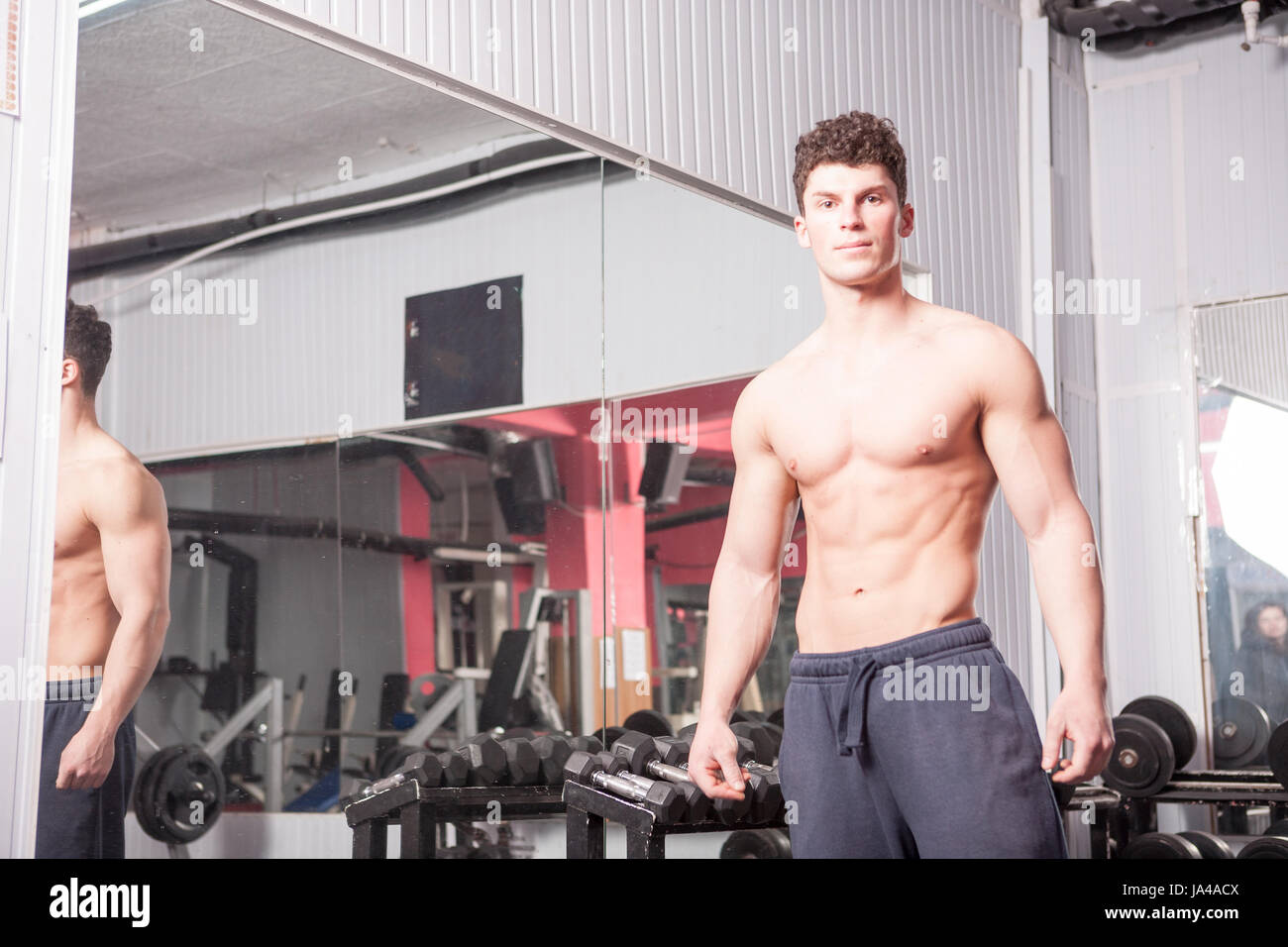 Strong muscular guy in the gym. Lifting heavy weights. Bodybuilder ...