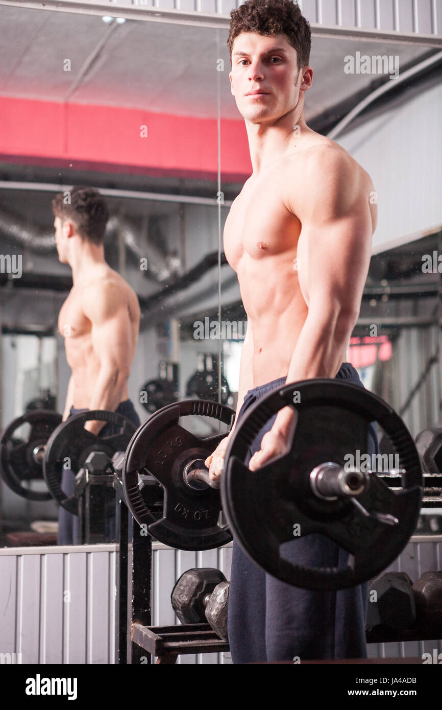 Exercising in the gym with heavy weights. Lifting heavy weights ...