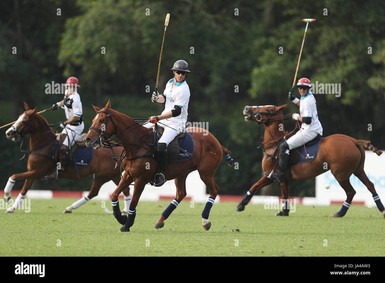 Prince Harry (centre) takes part in the Sentebale Royal Salute Polo Cup ...