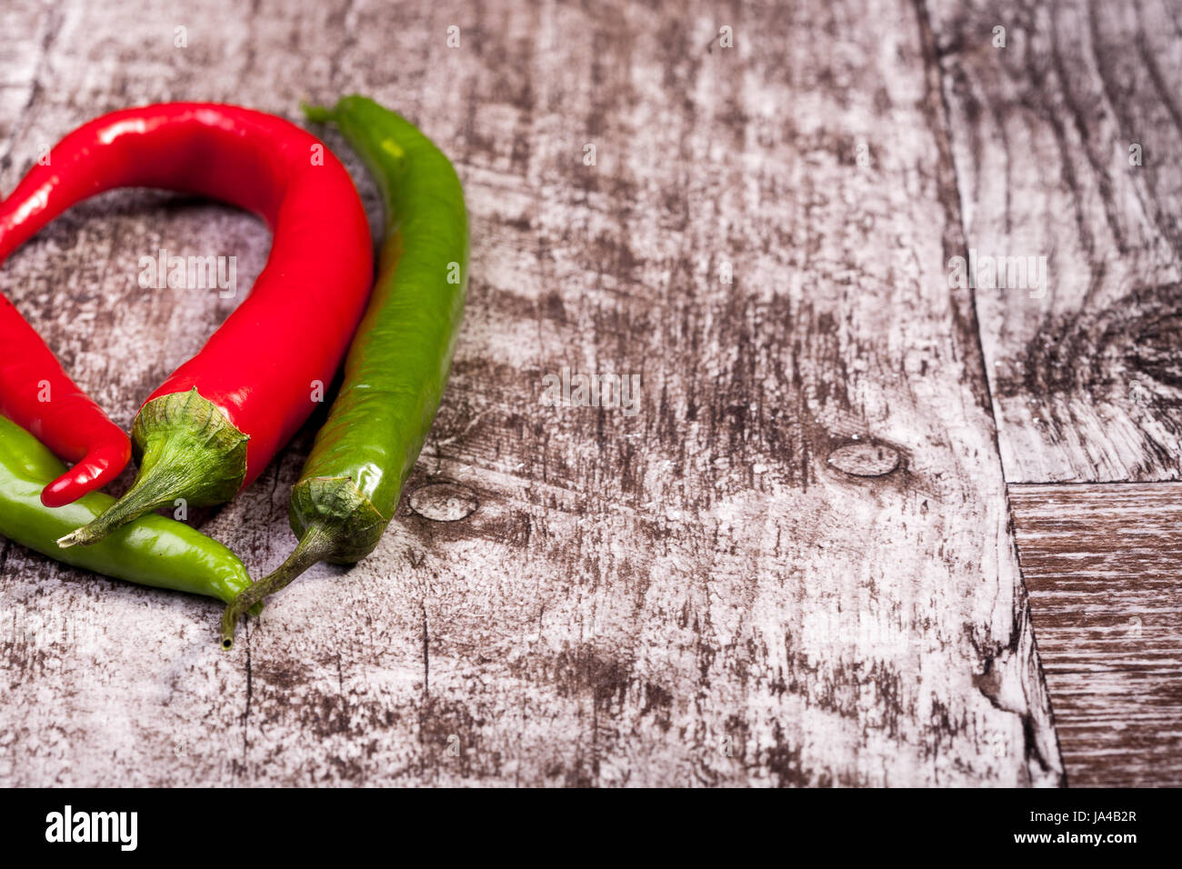 Green and red spicy papper on wooden background in studio photo. Fresh ...