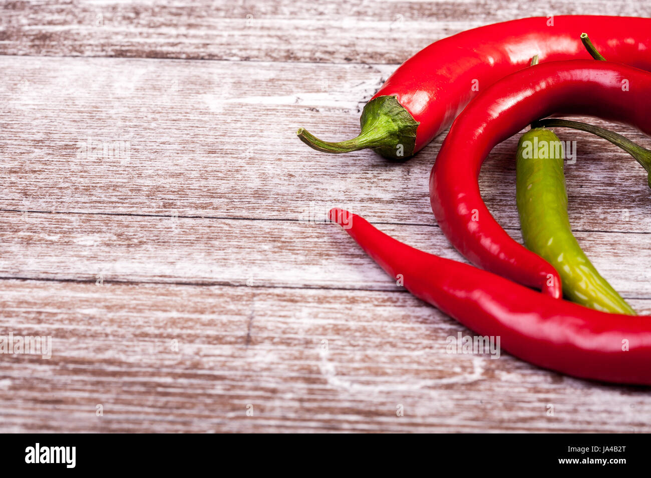 Green and red spicy papper on wooden background in studio photo. Fresh ...