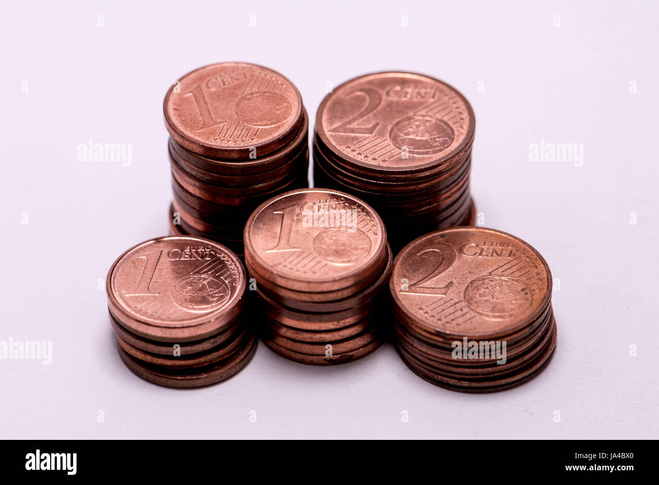 stacks of euro cents, one and two cents value, white background, copper ...