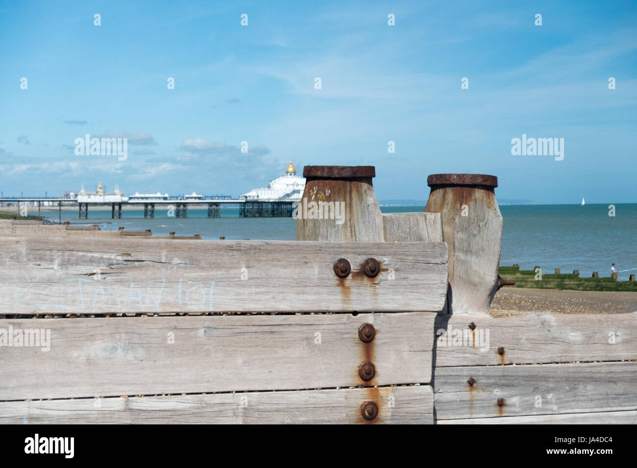 Eastbourne pier in the back ground behind wooden sea breakers on a ...