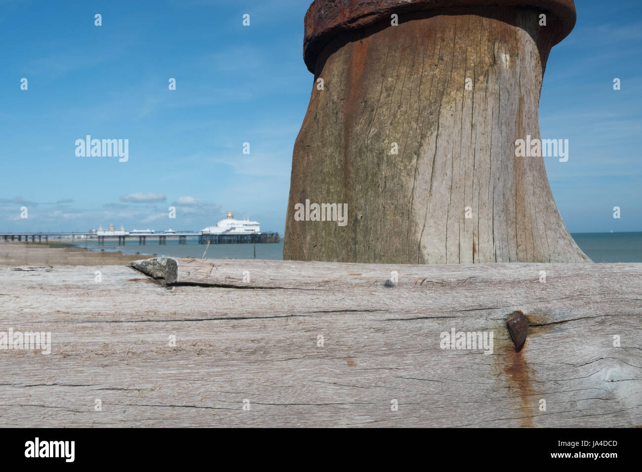 Eastbourne pier in the back ground behind wooden sea breakers on a ...