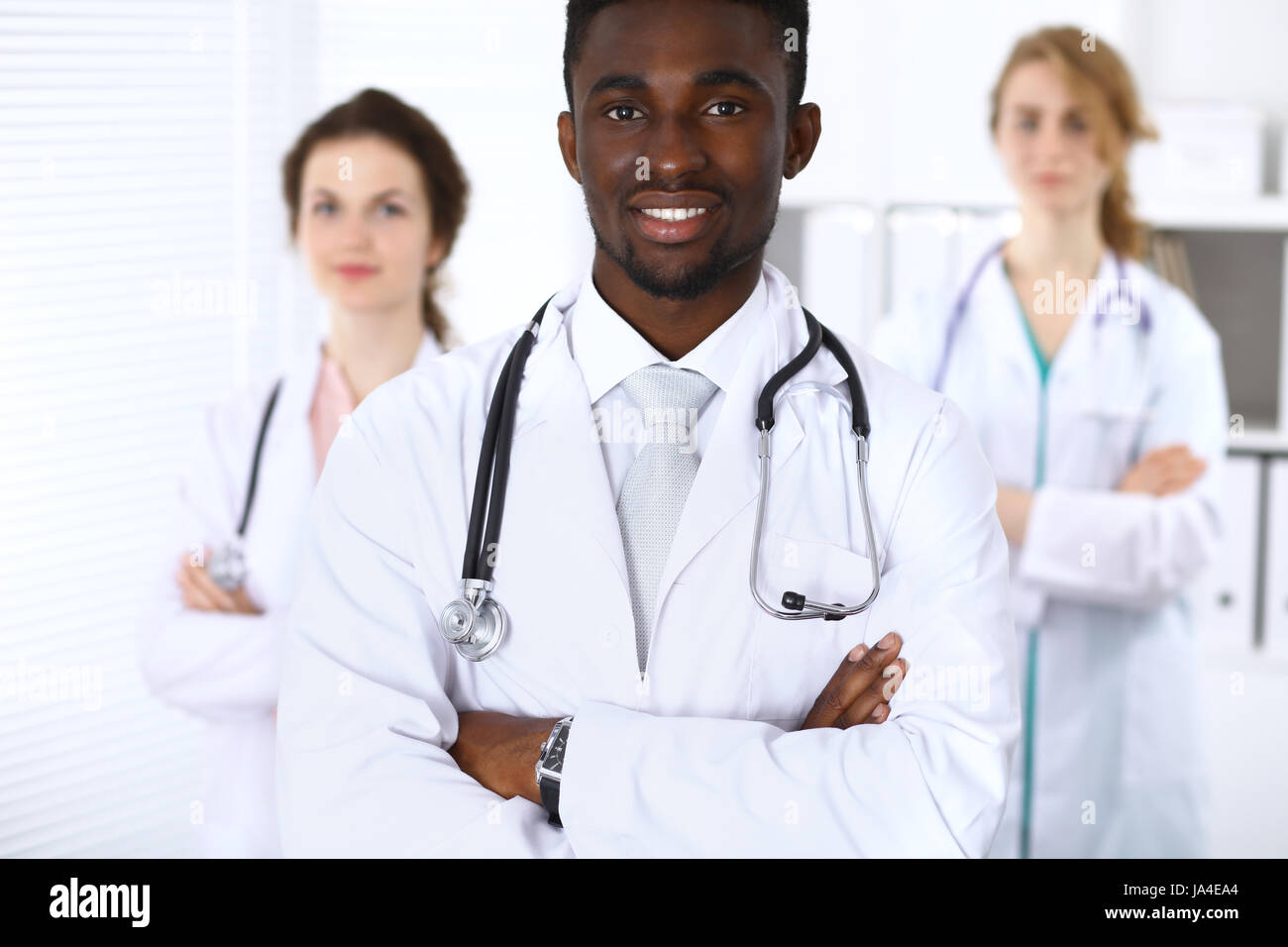 Happy african american male doctor with medical staff at the hospital ...