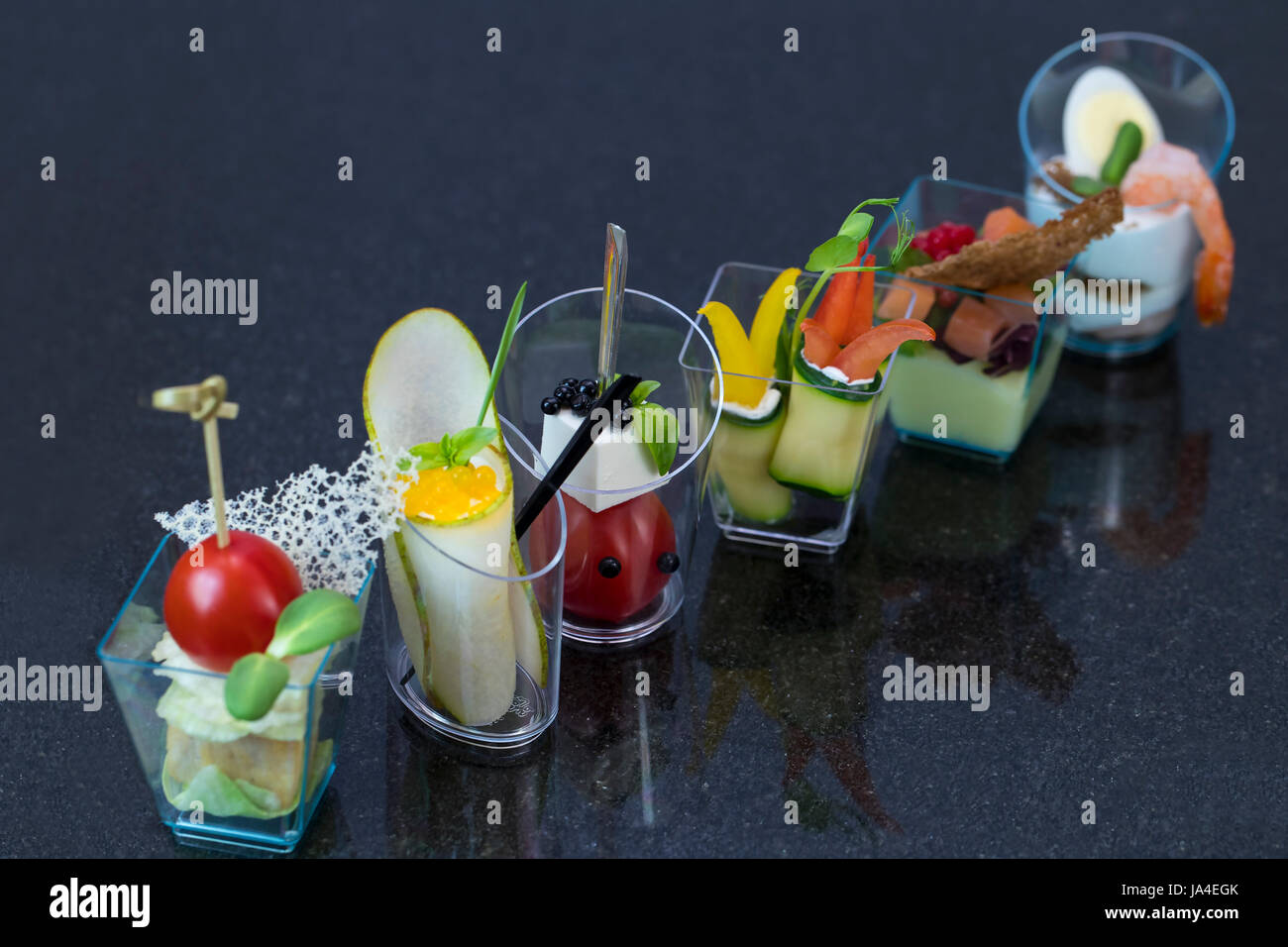 Mini desserts and meat canapes vegetable snacks in plastic cups canapes ...