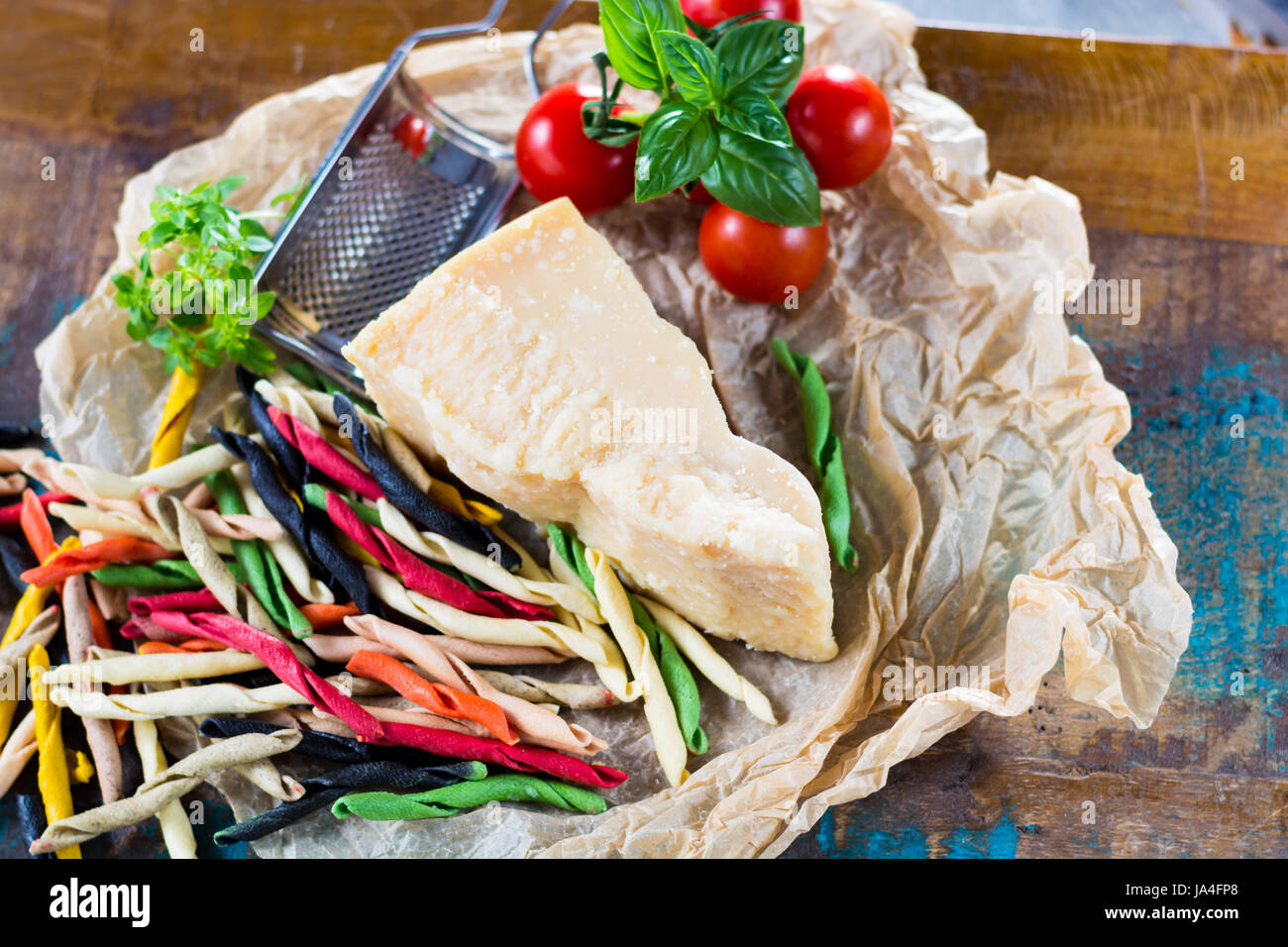 Traditional Italian hard cheese Parmesan with pasta, tomatoes, basil on ...
