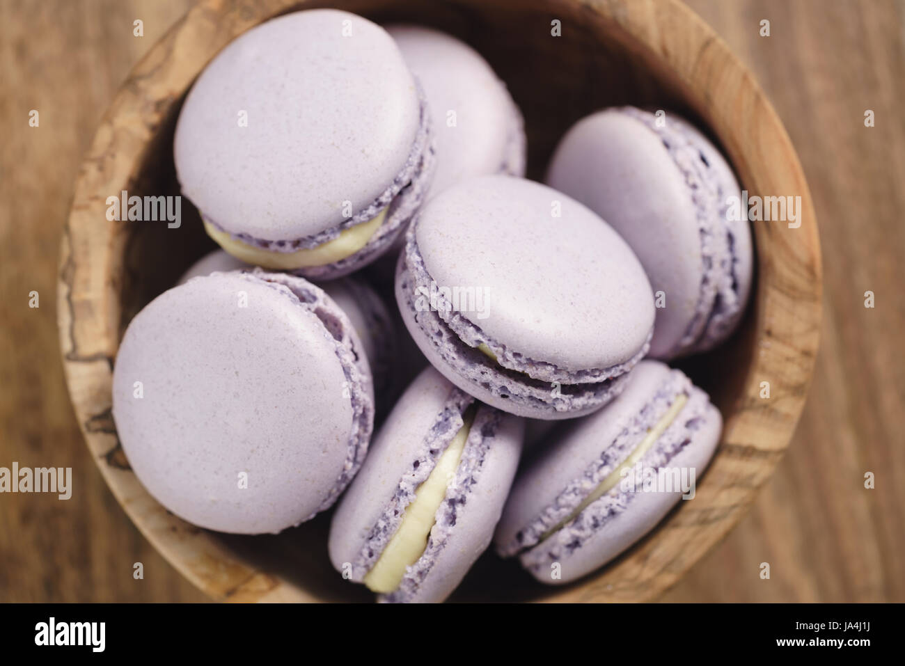 violet macarons in wood bowl on wooden table Stock Photo - Alamy