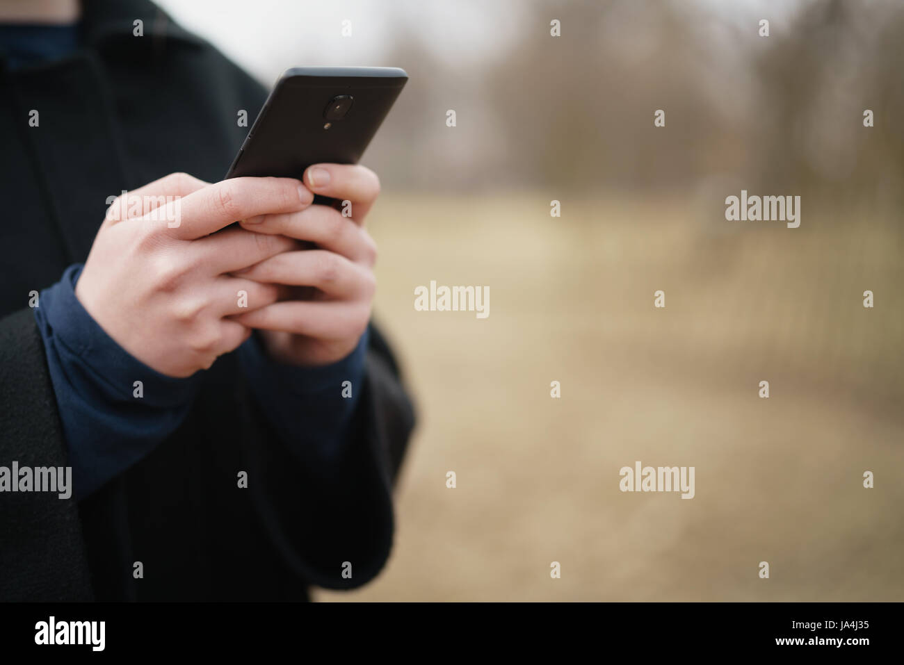female young hands using smartphone outdoors in cold spring Stock Photo ...