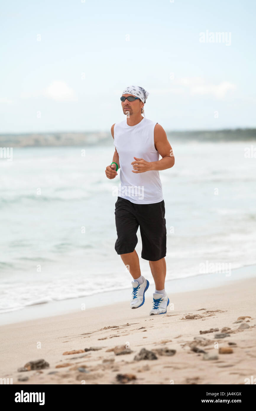 adult athletic man jogging on the beach Stock Photo - Alamy