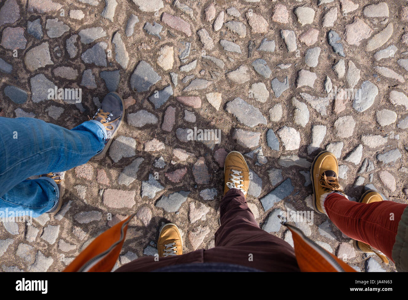 Three friends walk in shoes along the pavement. Walk in the fresh air ...