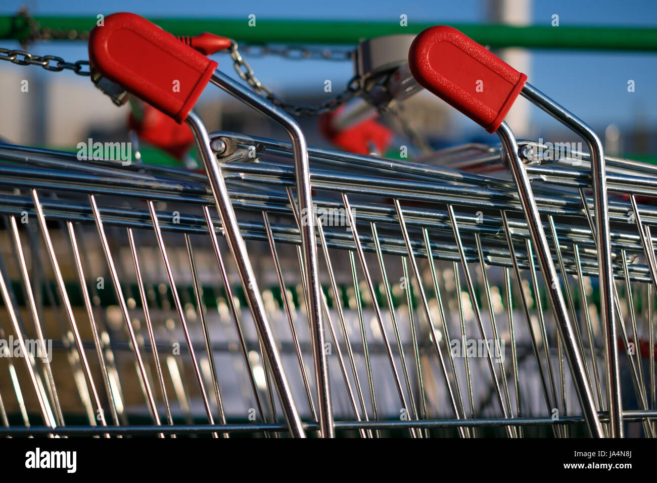 Two shopping carts connected by a chain Stock Photo - Alamy