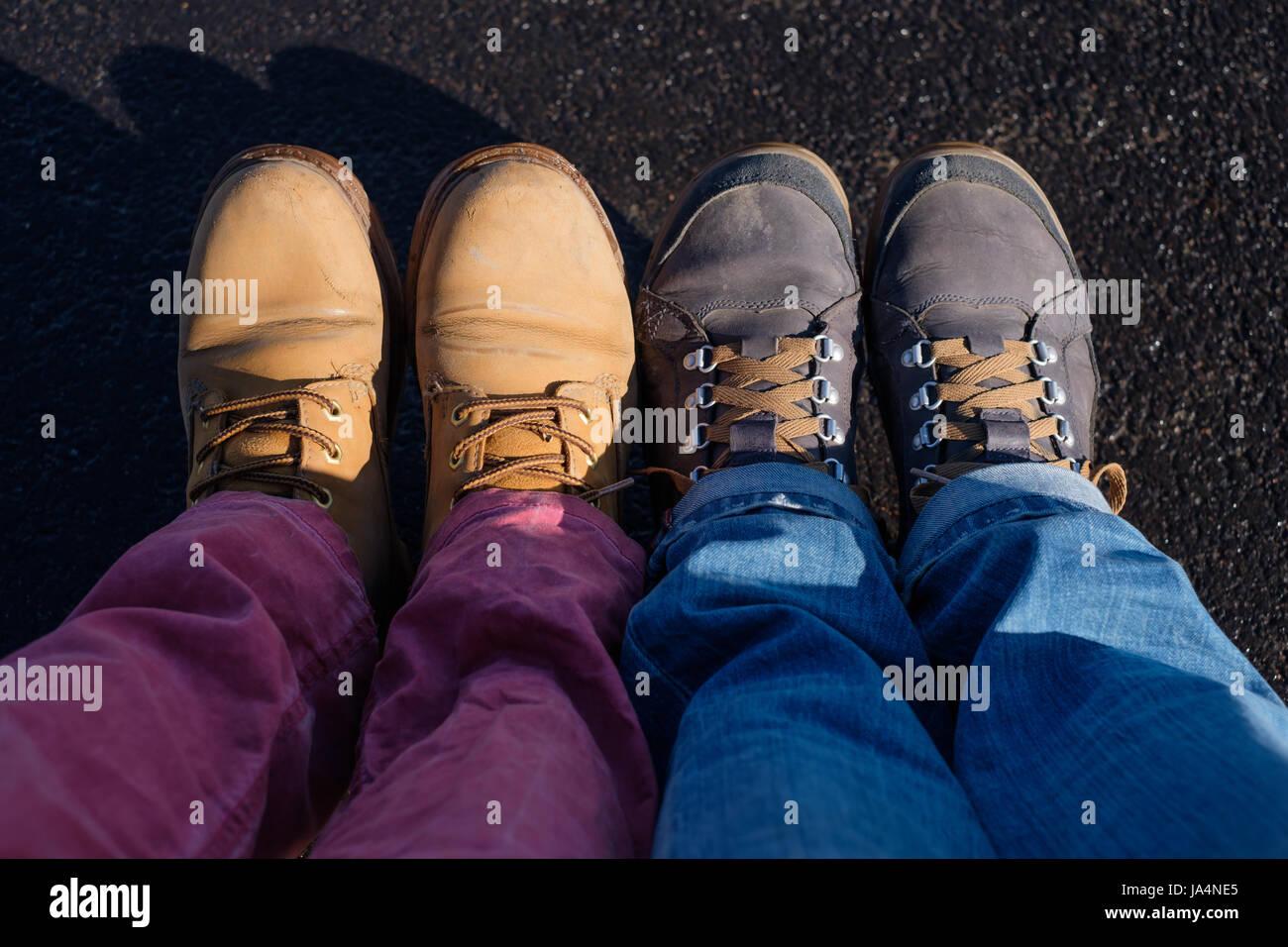 A couple of friends are sitting next to each other. Multicolored pants ...