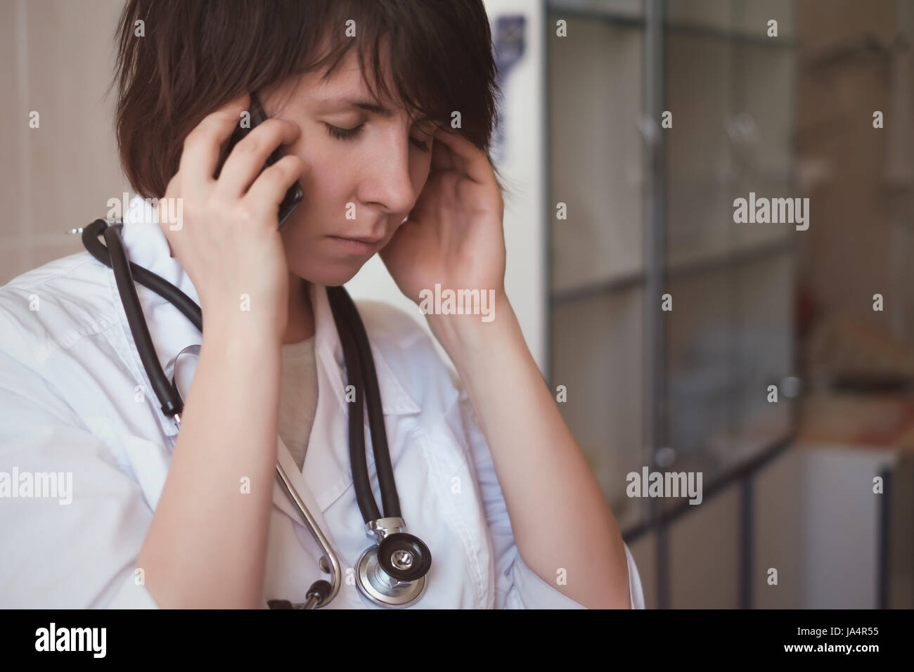 A young tired doctor talks on the phone after a difficult day Stock ...