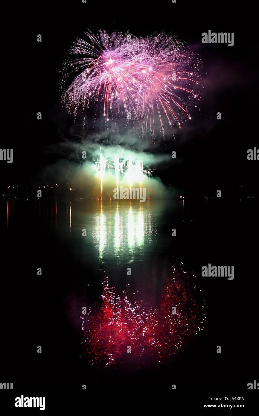 Beautiful colorful fireworks on the water surface with a clean black ...