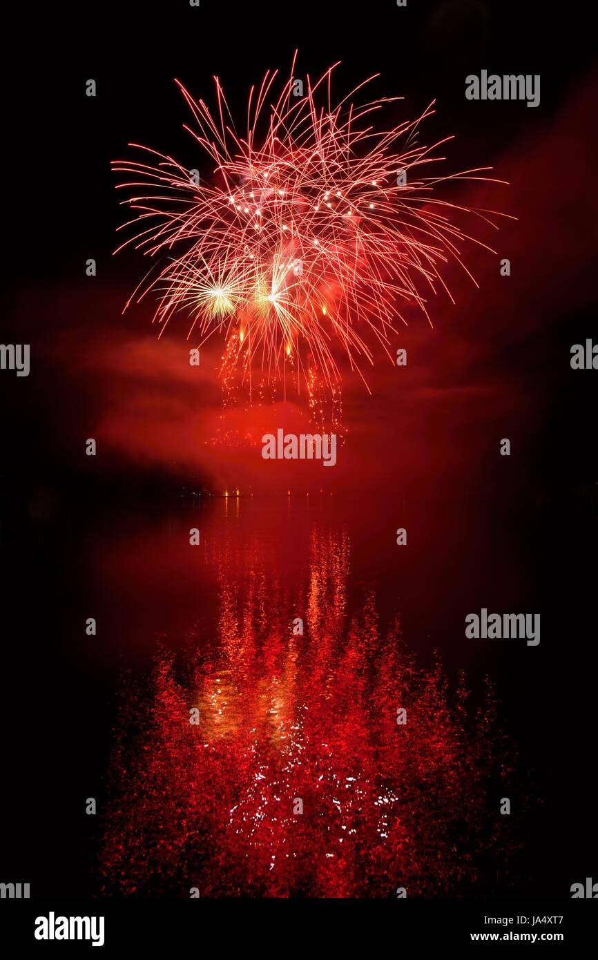 Beautiful colorful fireworks on the water surface with a clean black ...