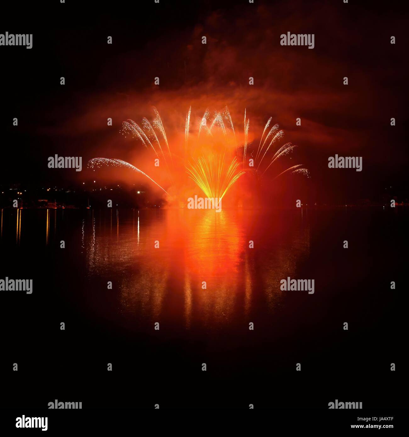 Beautiful colorful fireworks on the water surface with a clean black ...