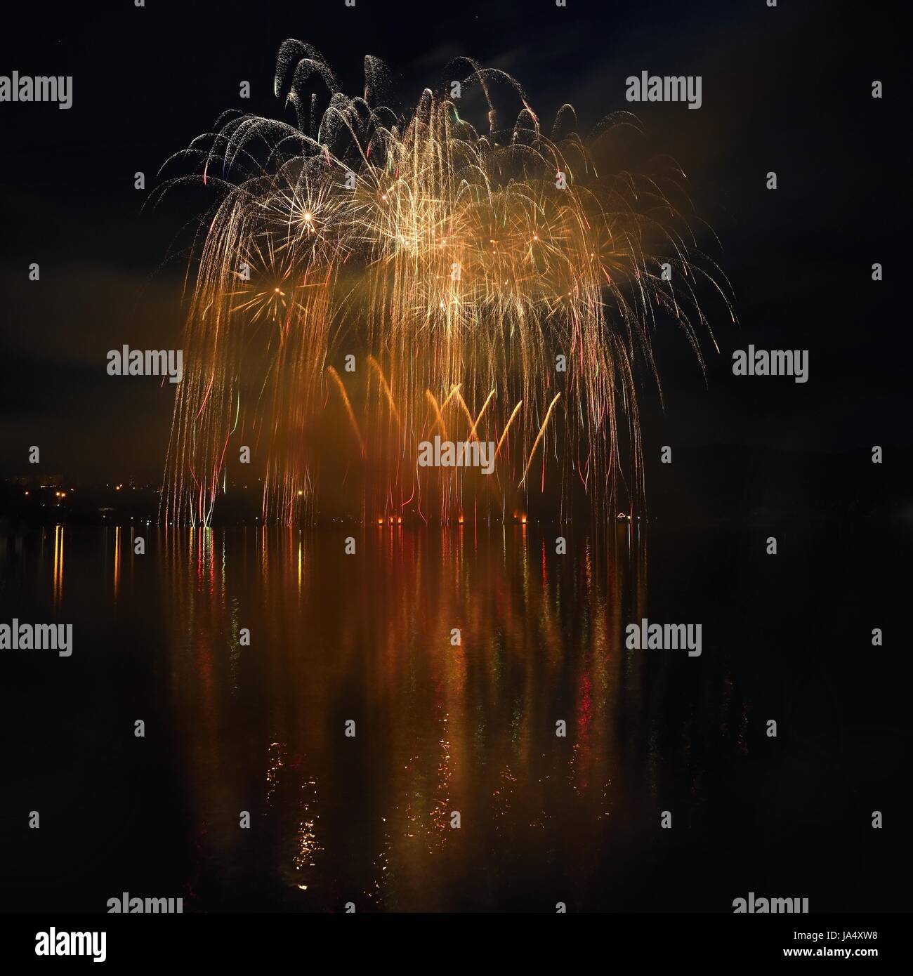 Beautiful colorful fireworks on the water surface with a clean black ...