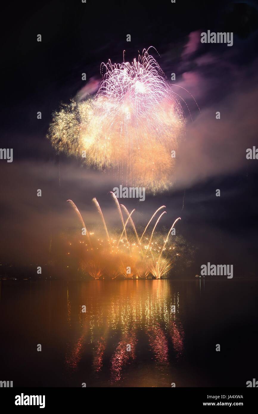 Beautiful colorful fireworks on the water surface with a clean black ...