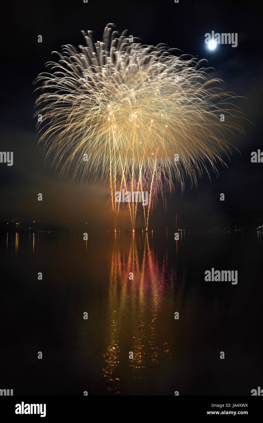 Beautiful colorful fireworks on the water surface with a clean black ...