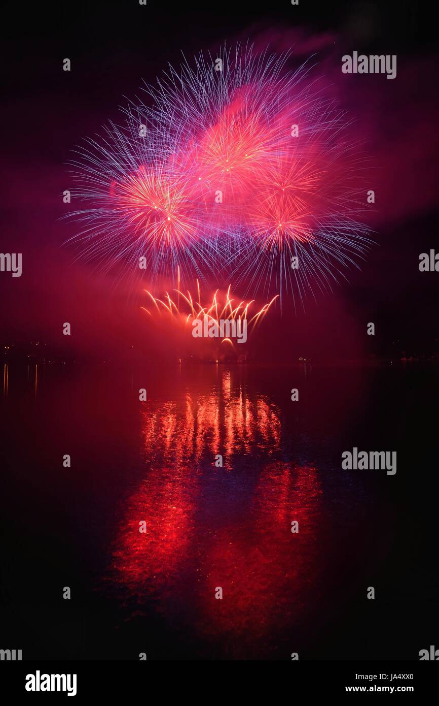 Beautiful colorful fireworks on the water surface with a clean black ...