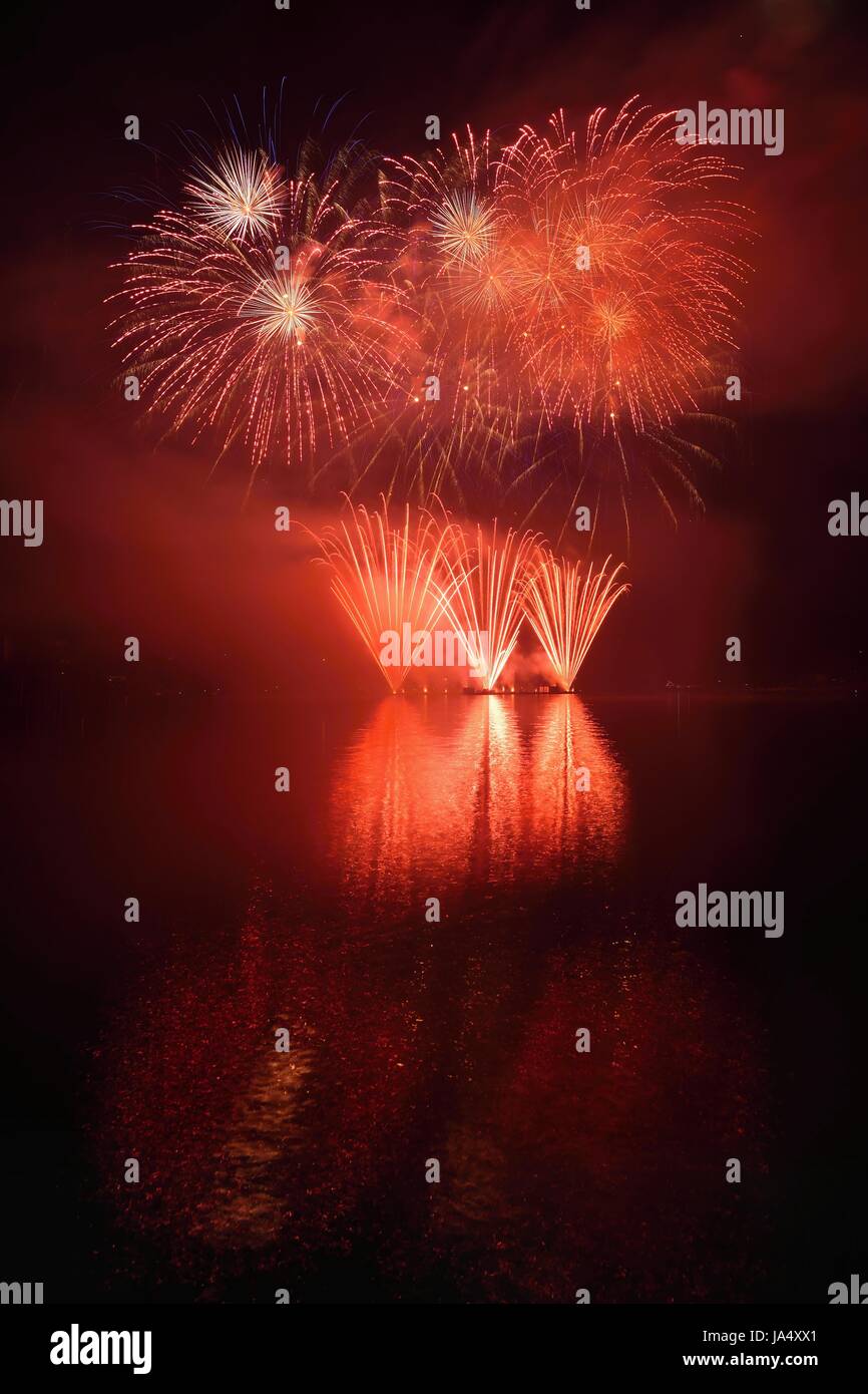 Beautiful colorful fireworks on the water surface with a clean black ...