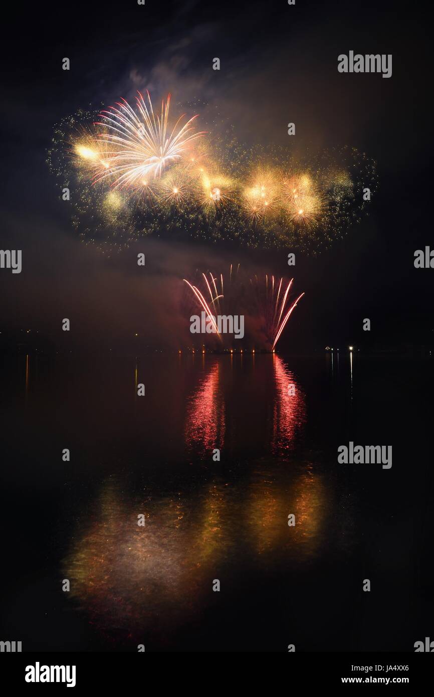 Beautiful colorful fireworks on the water surface with a clean black ...