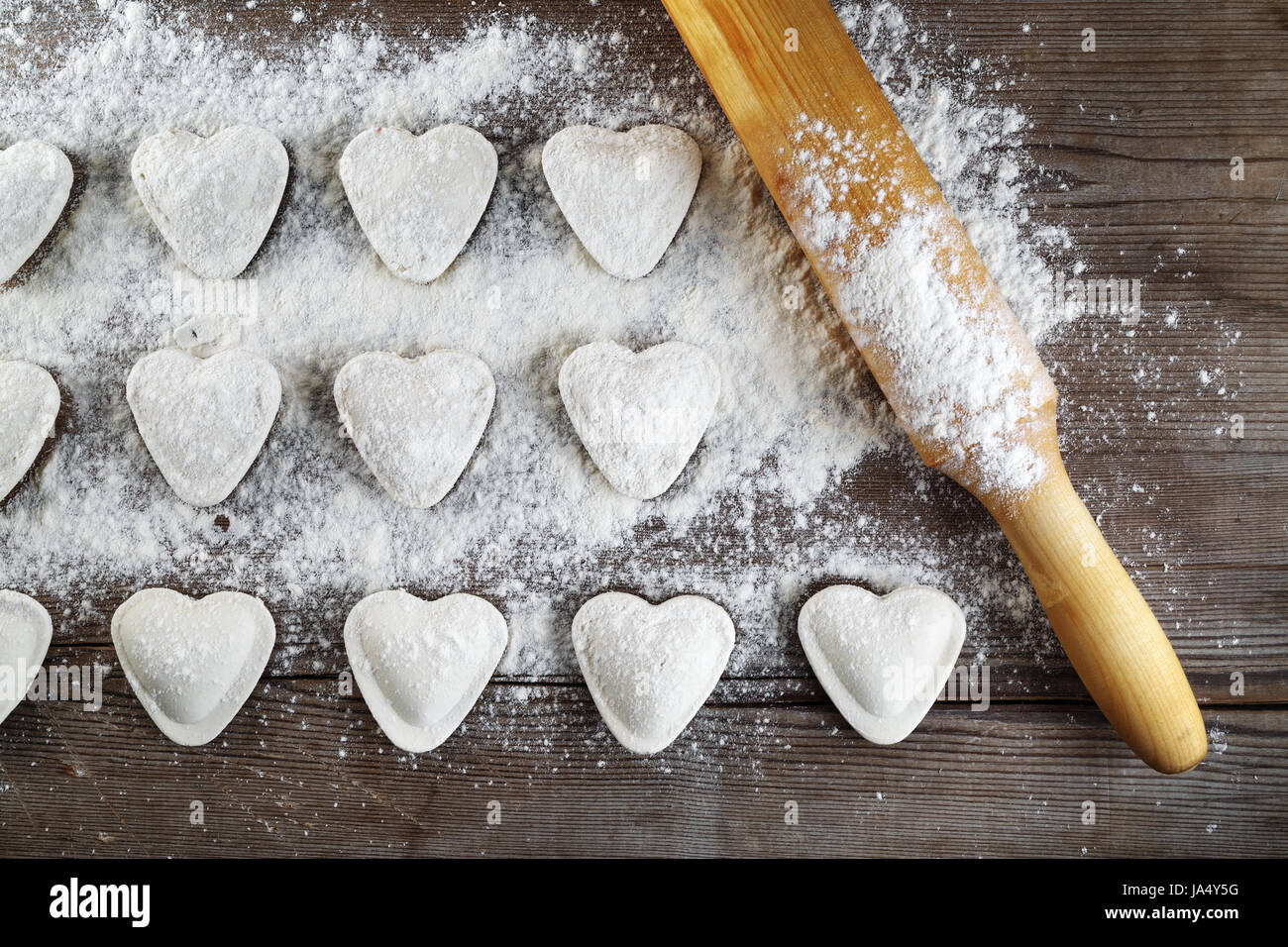Heart shaped ravioli with flou and rolling pin, on vintage wood table ... Heart shaped ravioli with flou and rolling pin, on vintage wood table ...