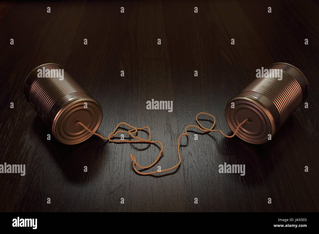 A retro homemade toy telephone made from two empty metal cans and a ...