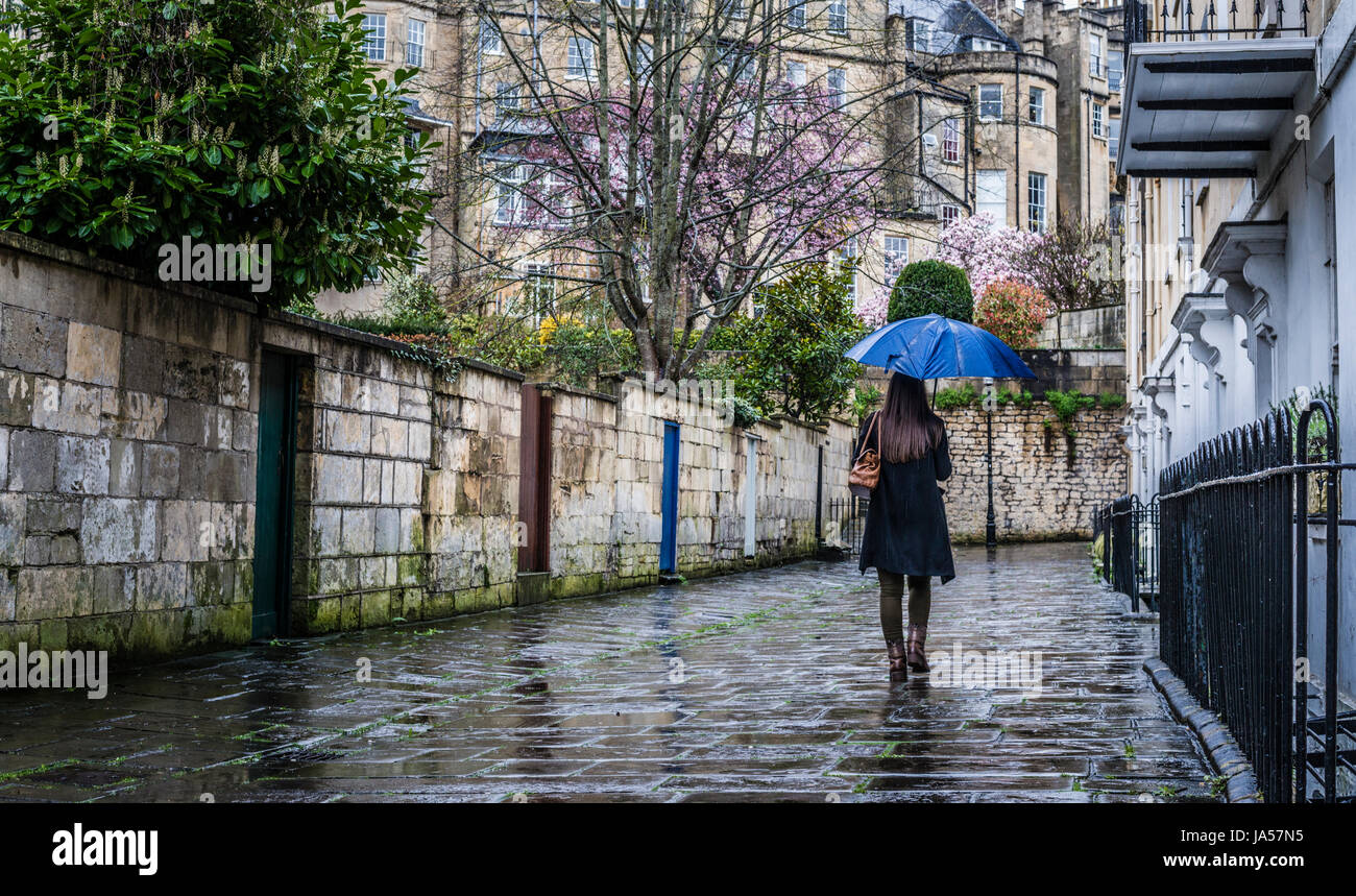 Woman walking down a quiet backstreet in the rain Stock Photo - Alamy