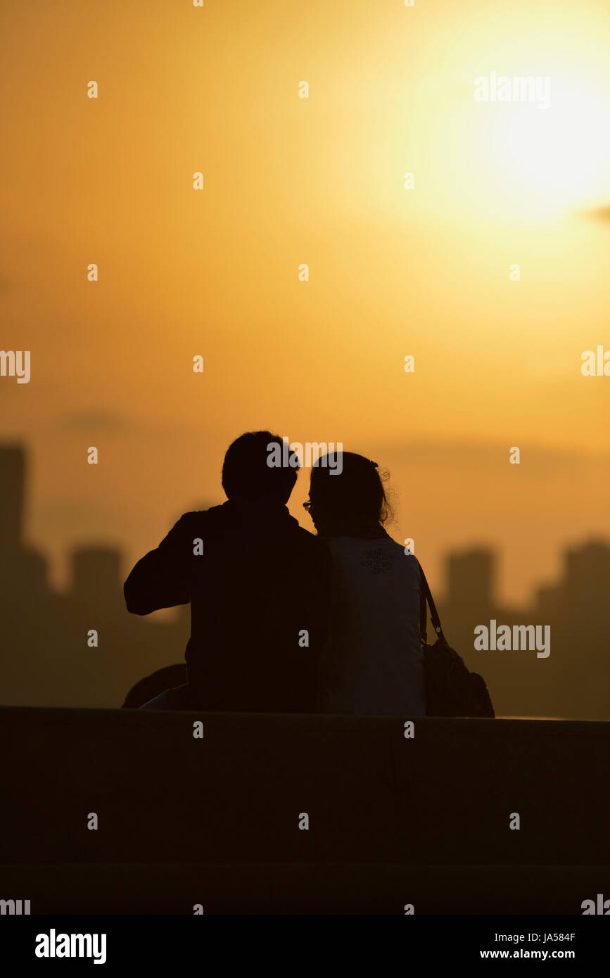 A couple in silhouette at sunset thinking about future facing sun Stock ...