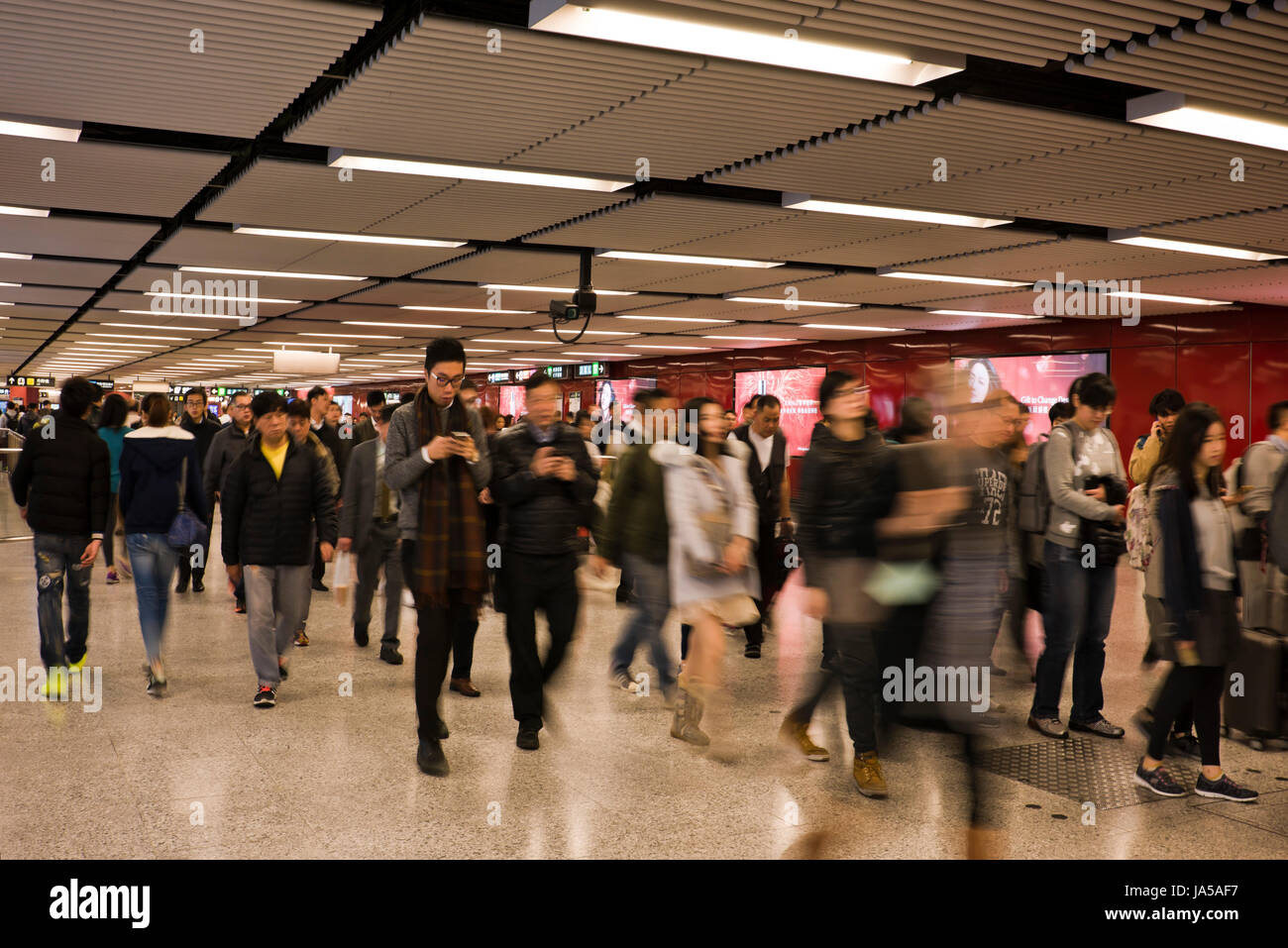Horizontal view of commuters rushing along the concourse of the MTR ...