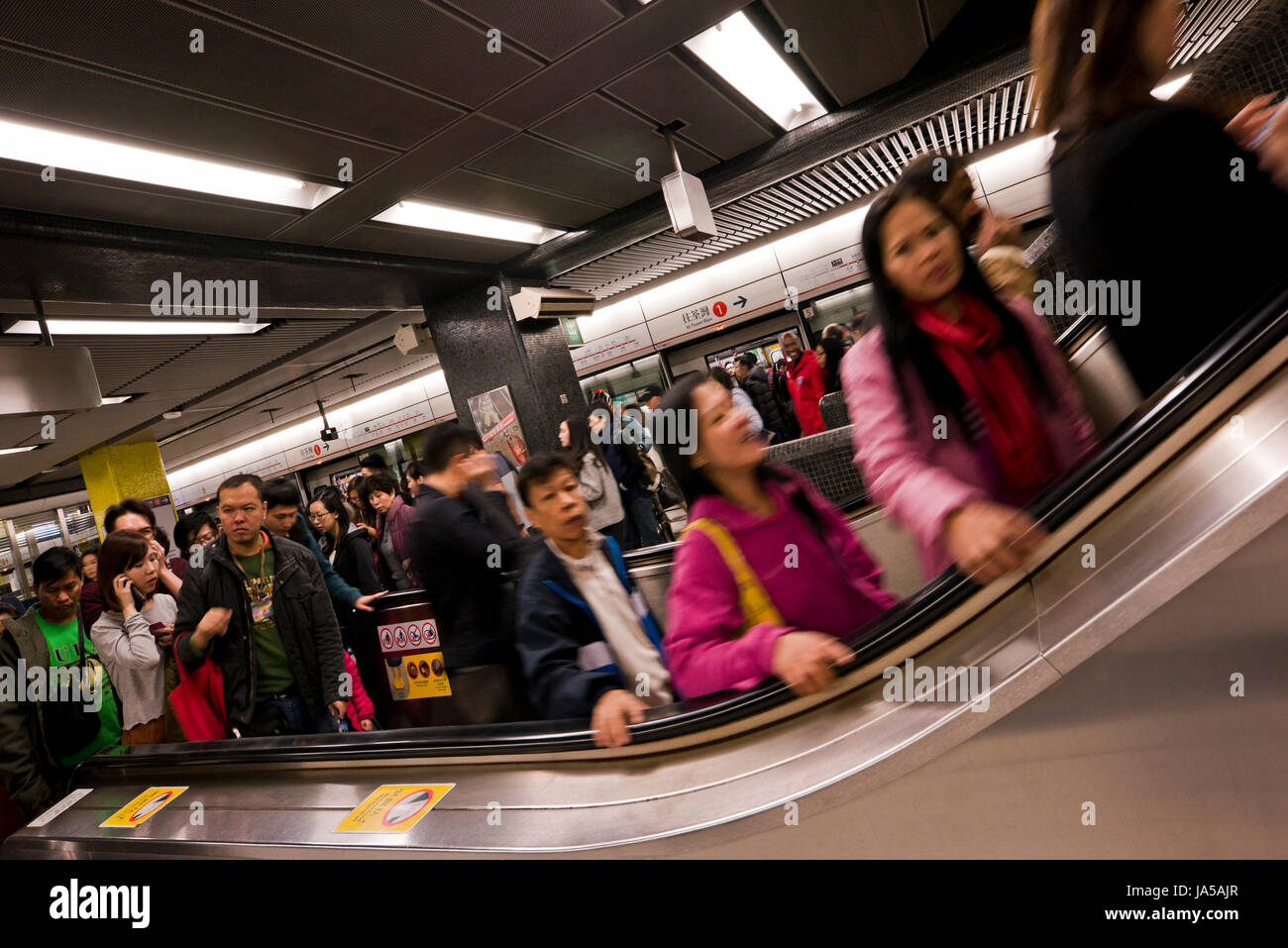 Horizontal view of people on the escalator at the MTR, mass transit ...