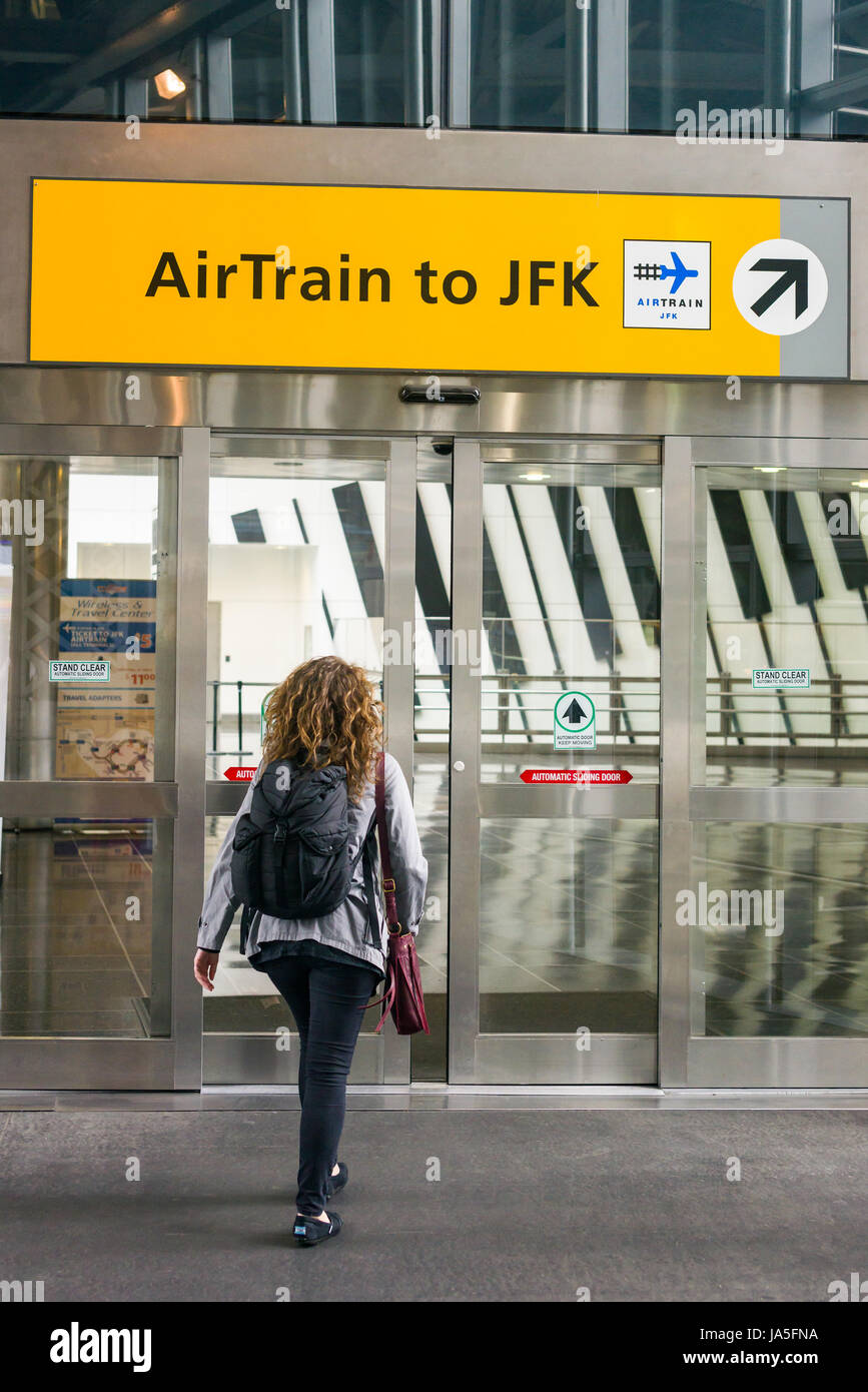 Female Passenger Walks Under a Sign For AirTrain to JFK Airport, New ...