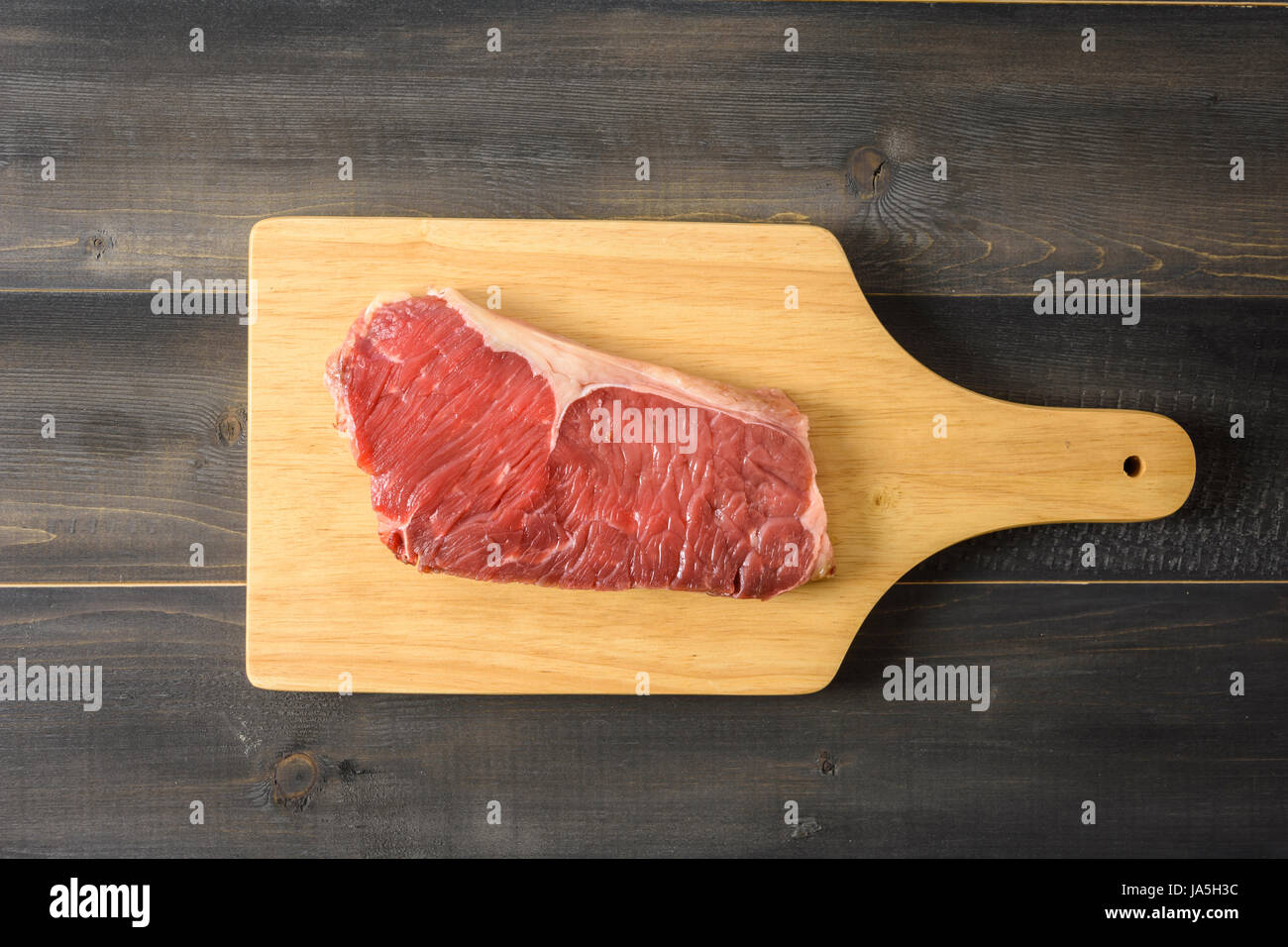 raw beef striploin steak on cutting board on wooden, top view Stock ...