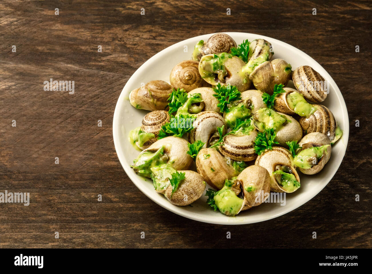 A photo of escargots a la bourguignonne, a plate of snails with the ...