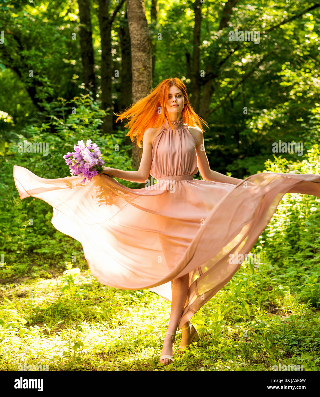 beautiful model in a forest with flowers Stock Photo - Alamy