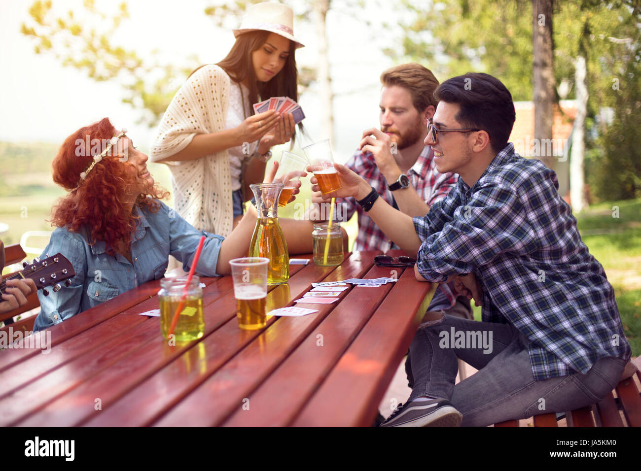 Young people amuse them self playing cards and toasting with beer Stock ...