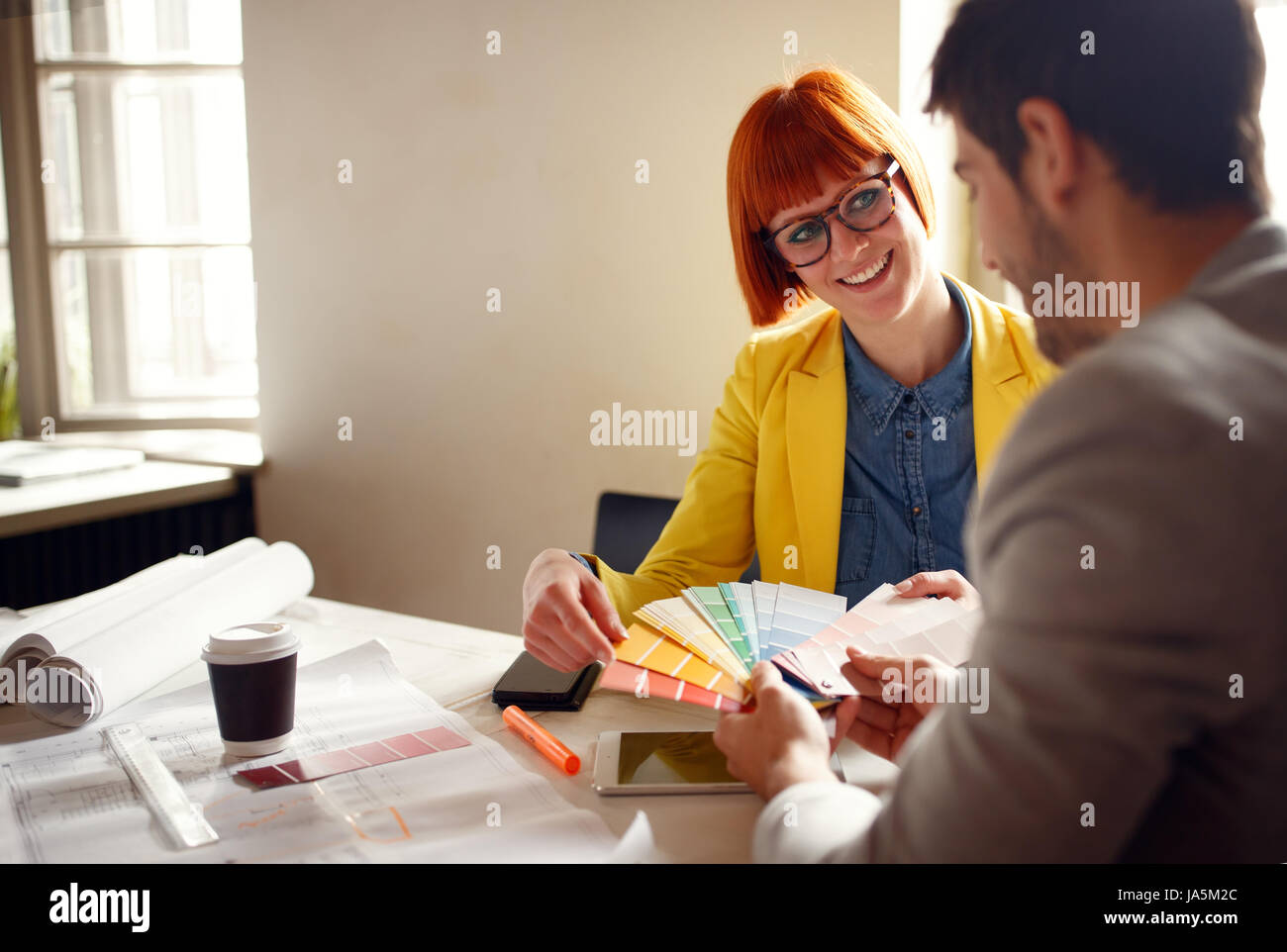 Working on design- modern couple designer discussing color palette ...