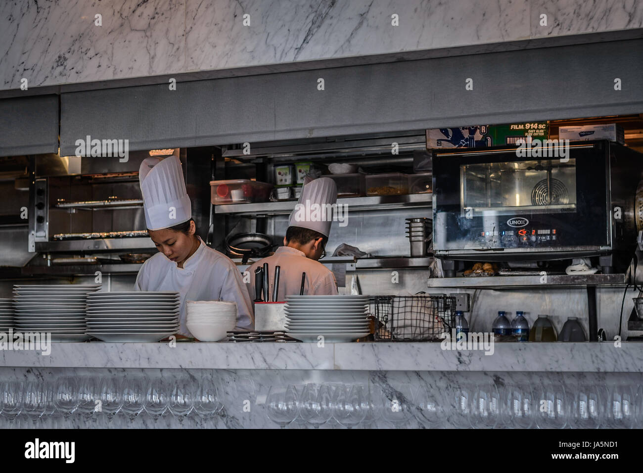 chefs cooking in open kitchen in uniform Stock Photo - Alamy