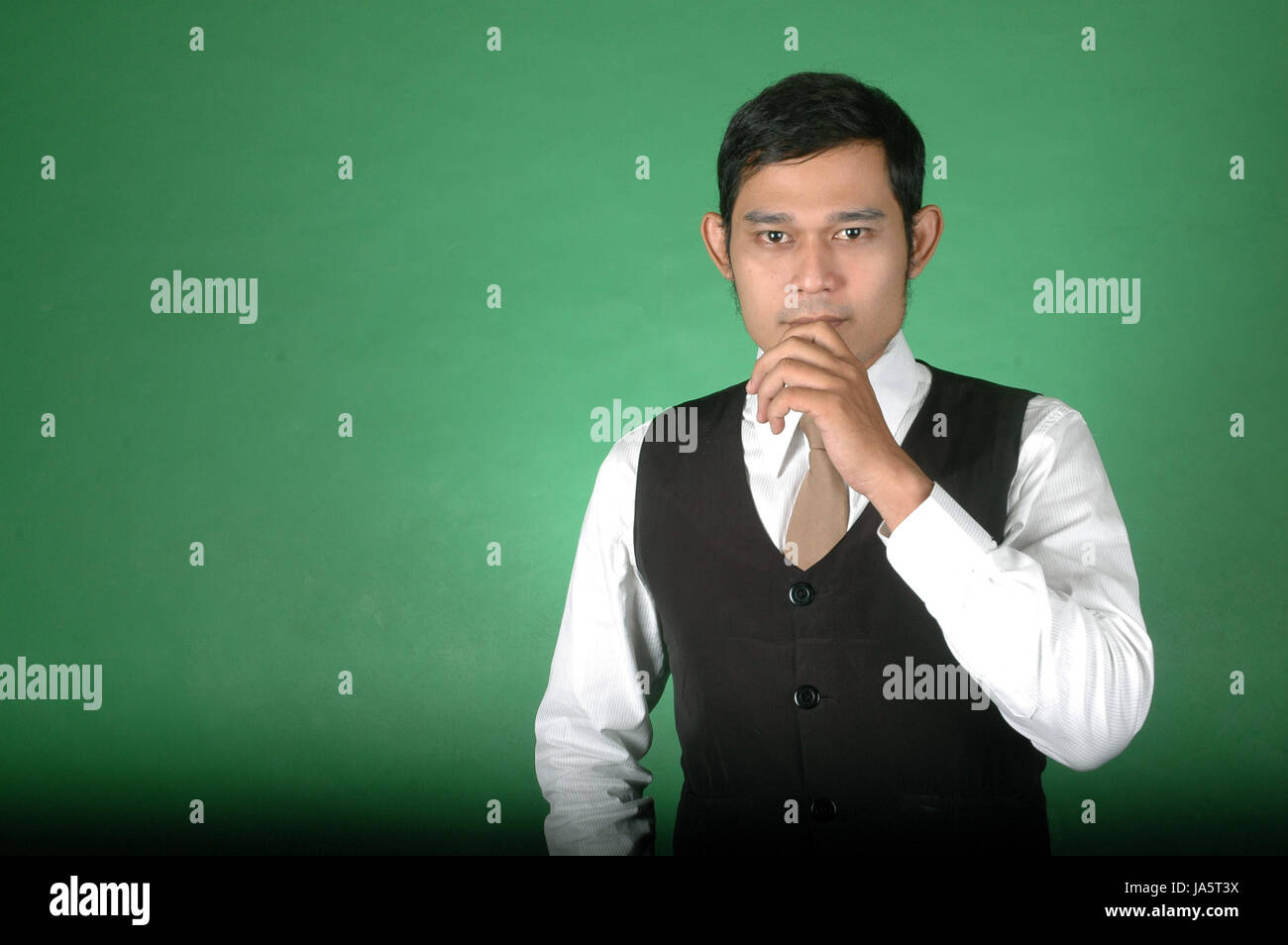 asian young man with posture was thinking against green background ...