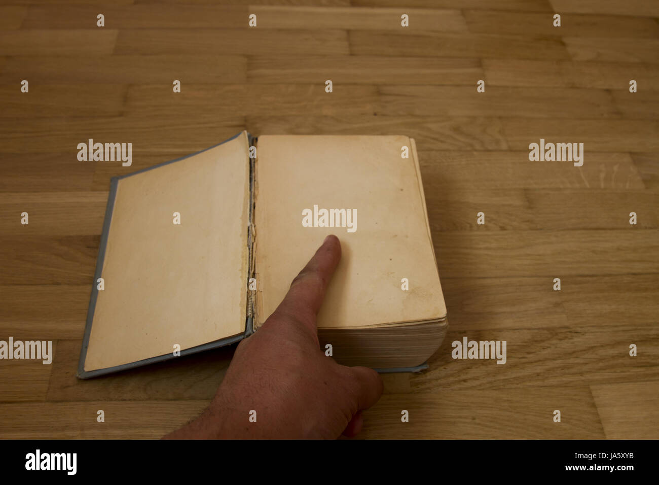 The finger points to something in the book Stock Photo - Alamy