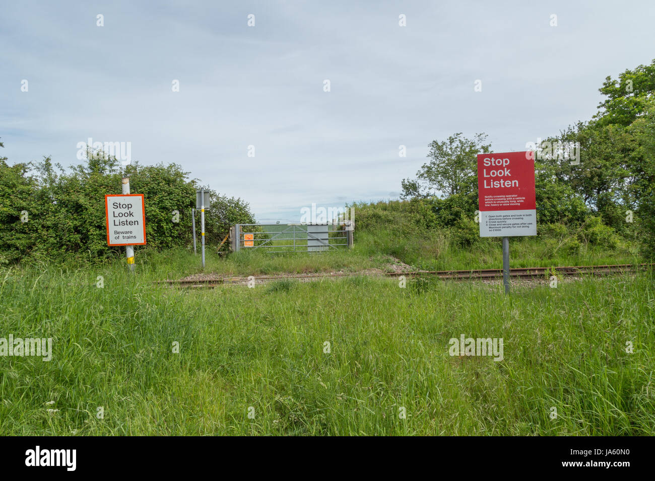 Two pedestrian warning signs at a railway crossing in the countryside ...