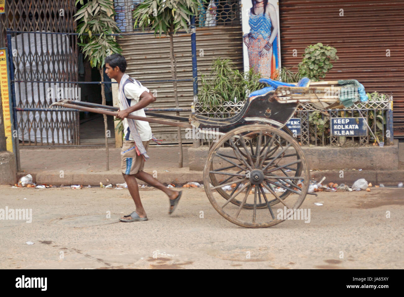 Man pulling a traditional hand pulled rickshaw along a street in ...